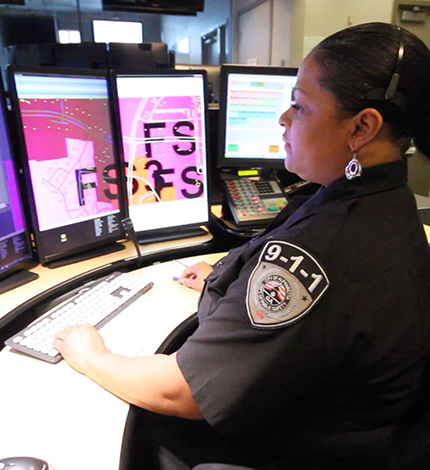 911 operator sitting in front of screens