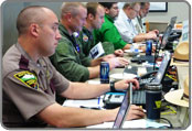 Image of officers sitting at computers as the Recovery Task Force
