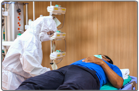 Hospital worker in full personal protective gear treating a patient.
